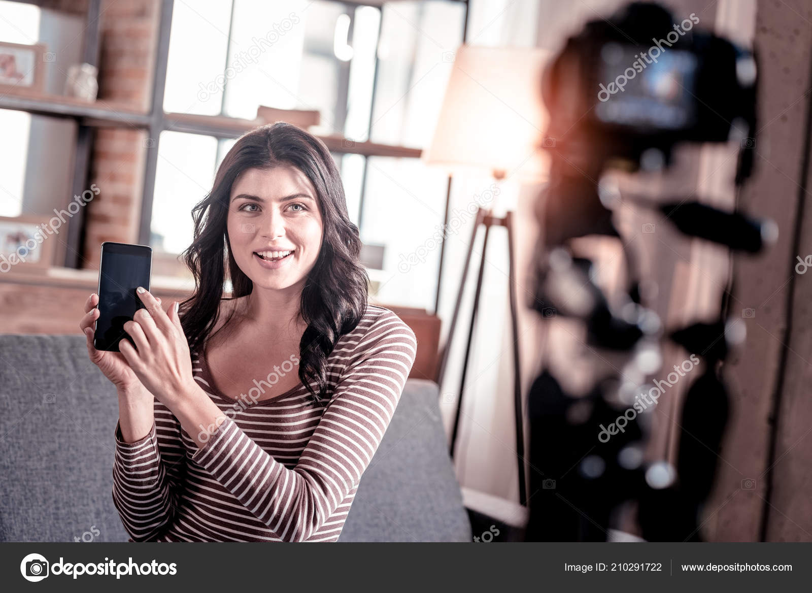 Delighted female vlogger holding her phone — Stock Photo © Dmyrto_Z ...