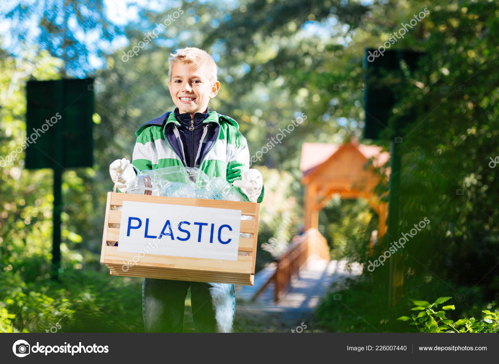 Cheerful cute boy cleaning the park from plastic Stock Photo by ©Dmyrto ...