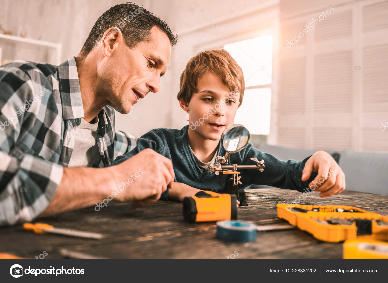 Father and son observing small things through the looking glass ...