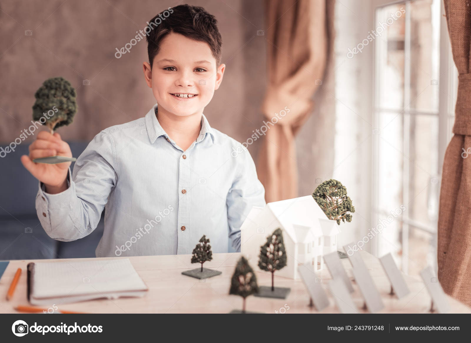 Smiling dark-haired boy holding model of tree — Stock Photo © Dmyrto_Z ...