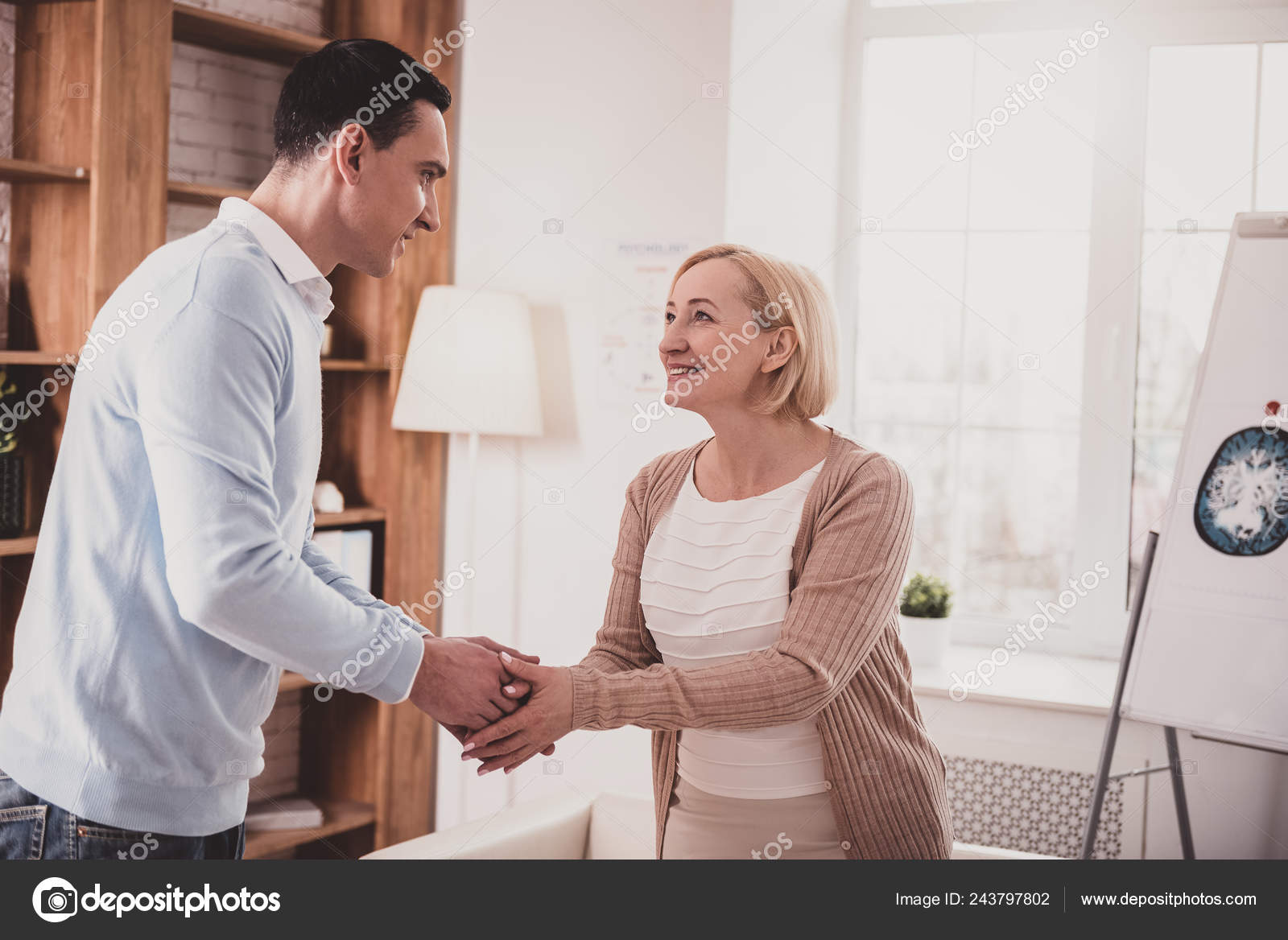 Kind woman welcoming her young business partner — Stock Photo © Dmyrto ...
