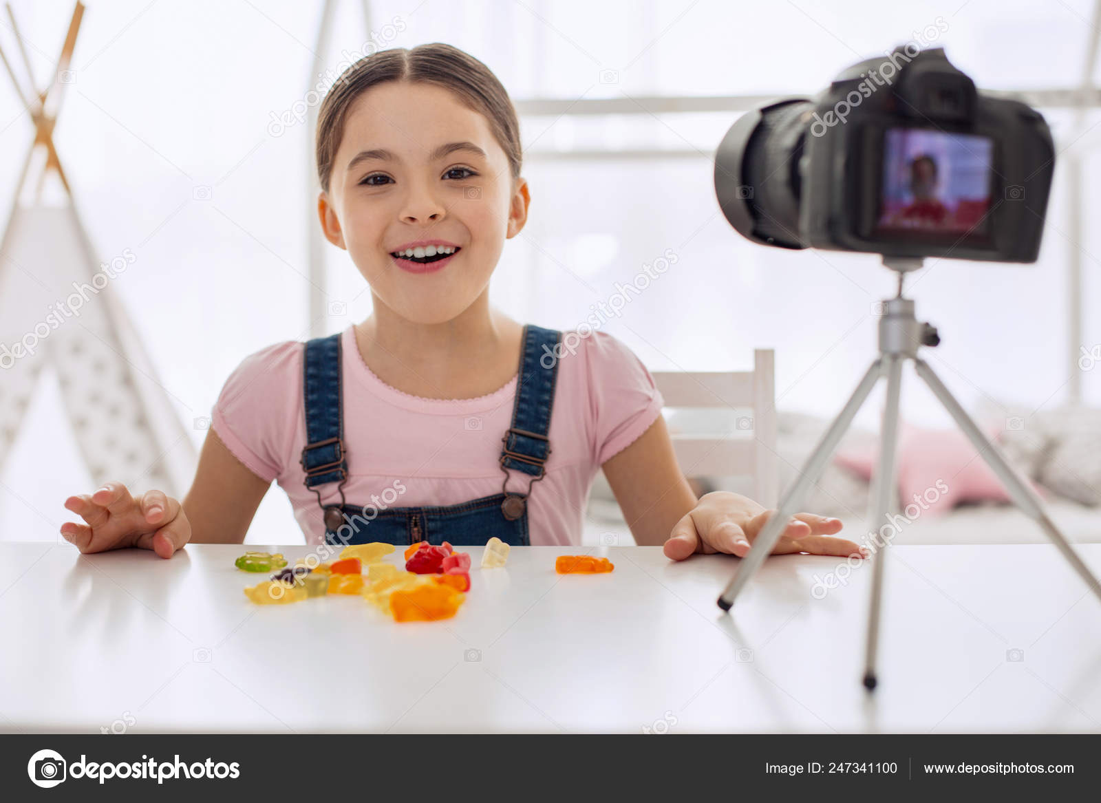 Overjoyed girl posing while eating gummies on camera — Stock Photo © Dmyrto_Z #247341100