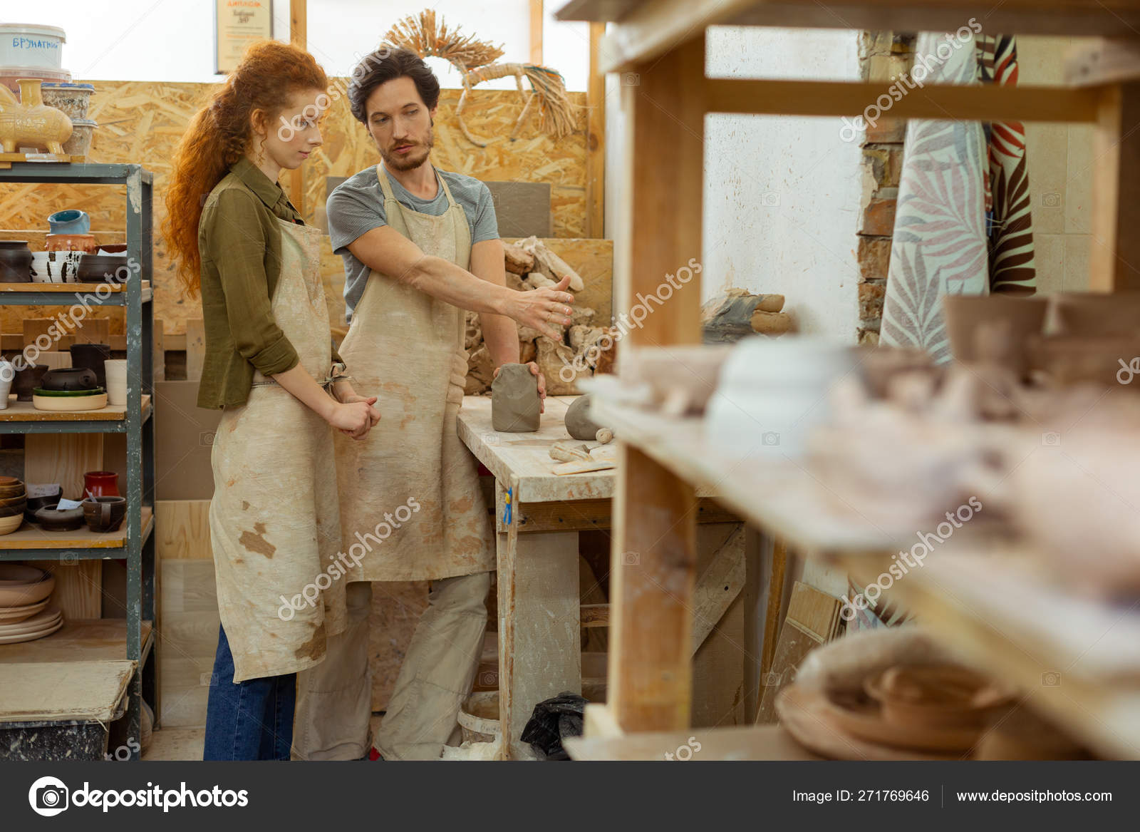 Smart professional pottery master explaining process to attentive woman ...