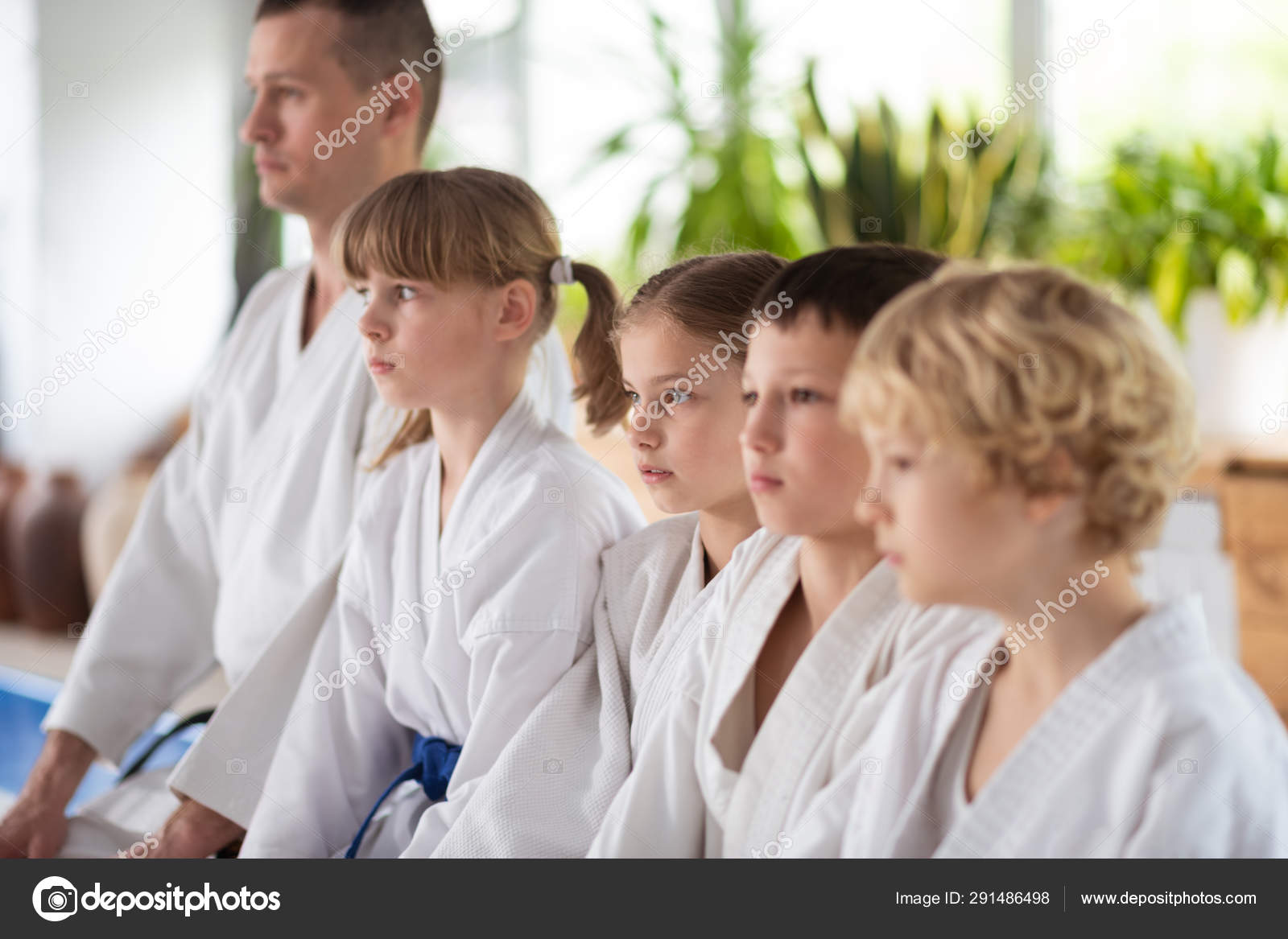 Children and their trainer wearing white kimono sitting on floor Stock ...
