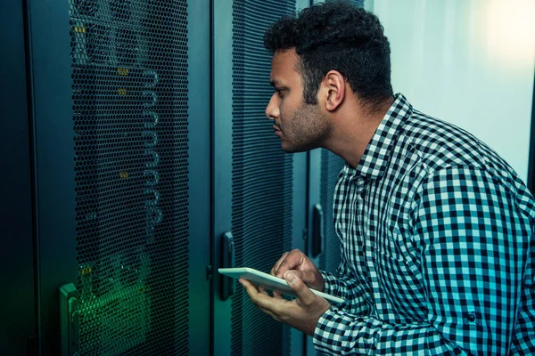 Serious smart young man looking at wires - Stock Image - Everypixel