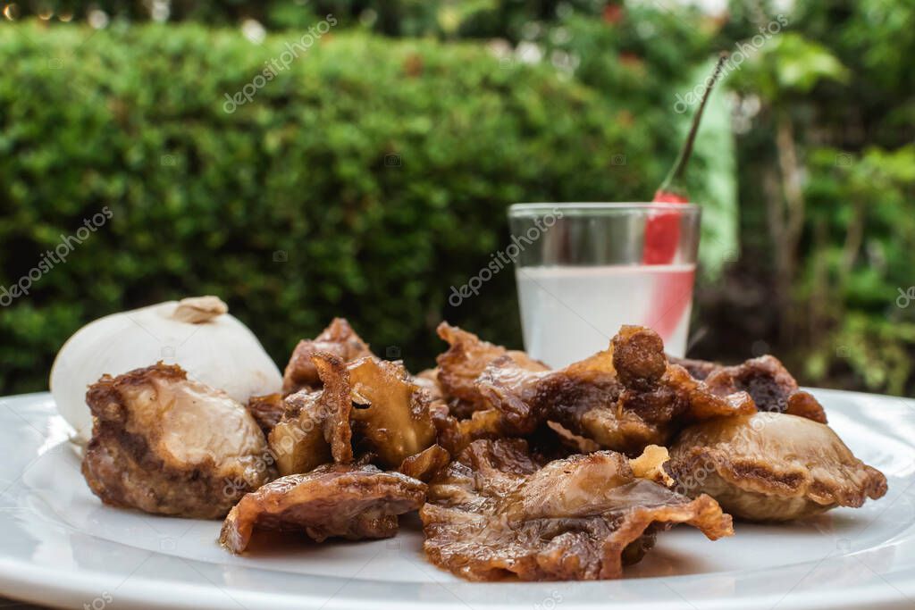 Chicharon bulaklak con vinagre y salsa de chile y una cabeza entera de ...