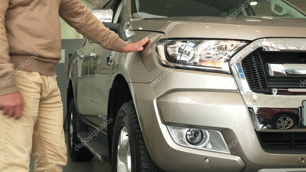 Un buen hombre llega a un coche nuevo y acaricia el autom vil con su ...