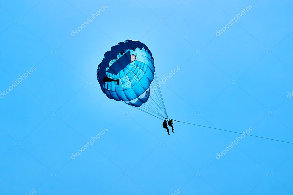 Parasailing volando sobre el fondo del cielo azul. El concepto de ...
