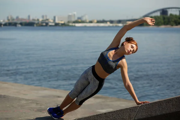 Full length side view of a attractive athletic woman side plank - Stock ...