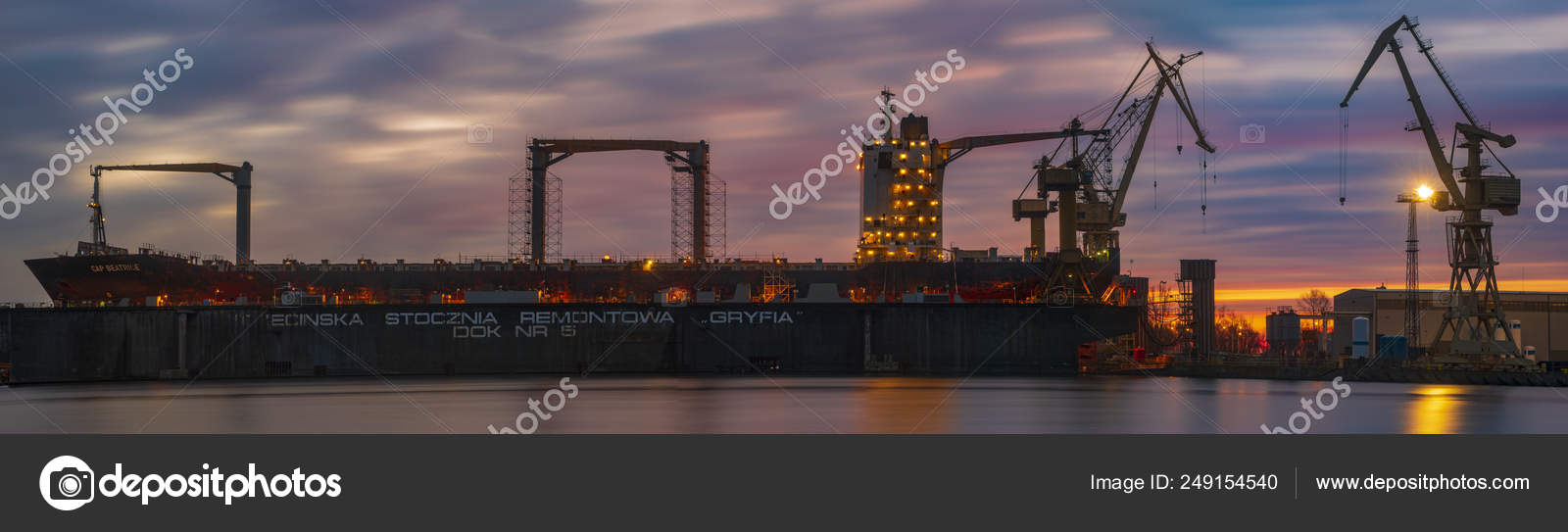 Merchant ship in the dry dock of the repair yard,panorama with h ...