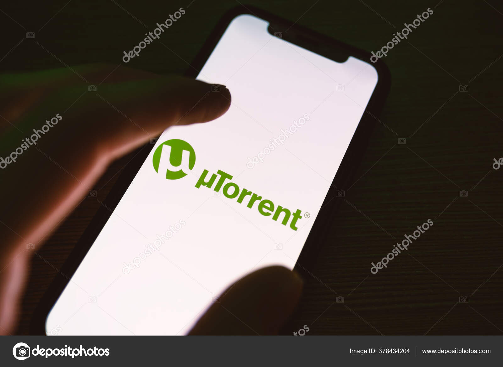 Hand holding smartphone with Torrent app logo on the screen. — Stock ...