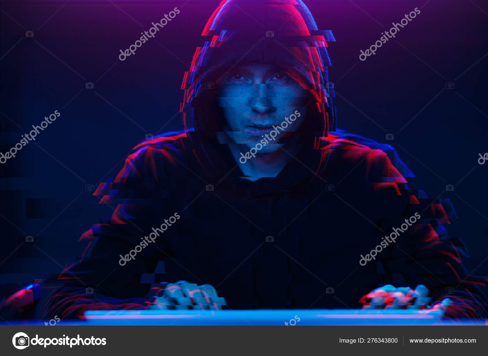 Hacker in the hood working with computer typing text in dark room. Image with glitch effect ...