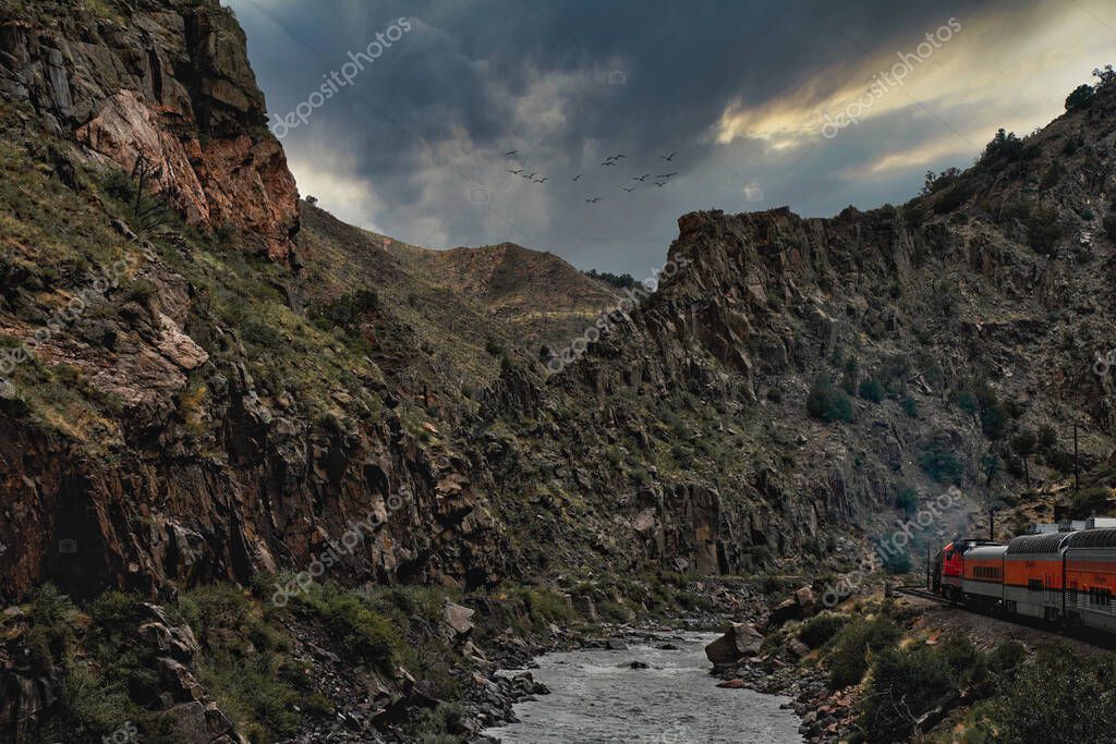 Tren por r o en un oscuro y sombr o barranco. Tren al lado del r o ...