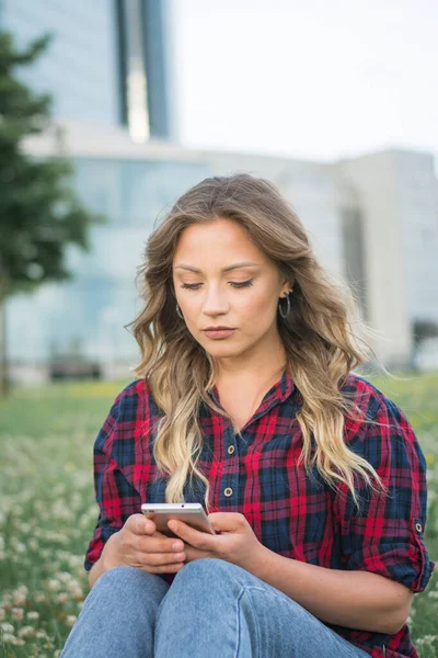 A beautiful caucasian college student texting on her cellphone a campus ...