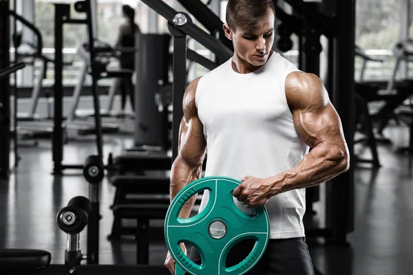 Muscular man working out in gym doing exercises with barbell at biceps, strong male Stock Photo ...