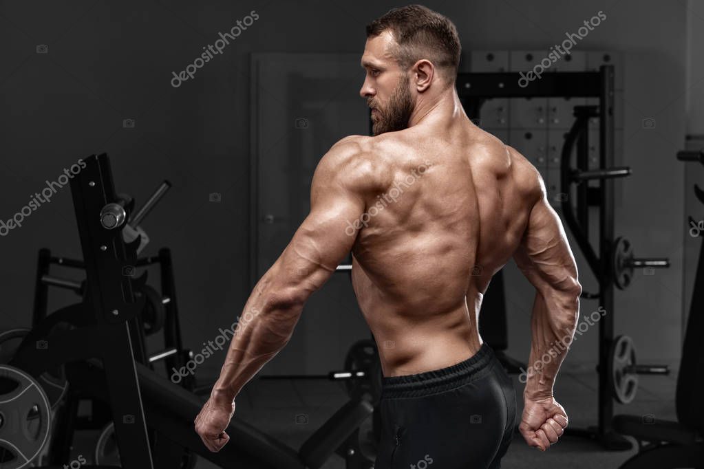 Vista trasera del hombre muscular que muestra los músculos de la ...