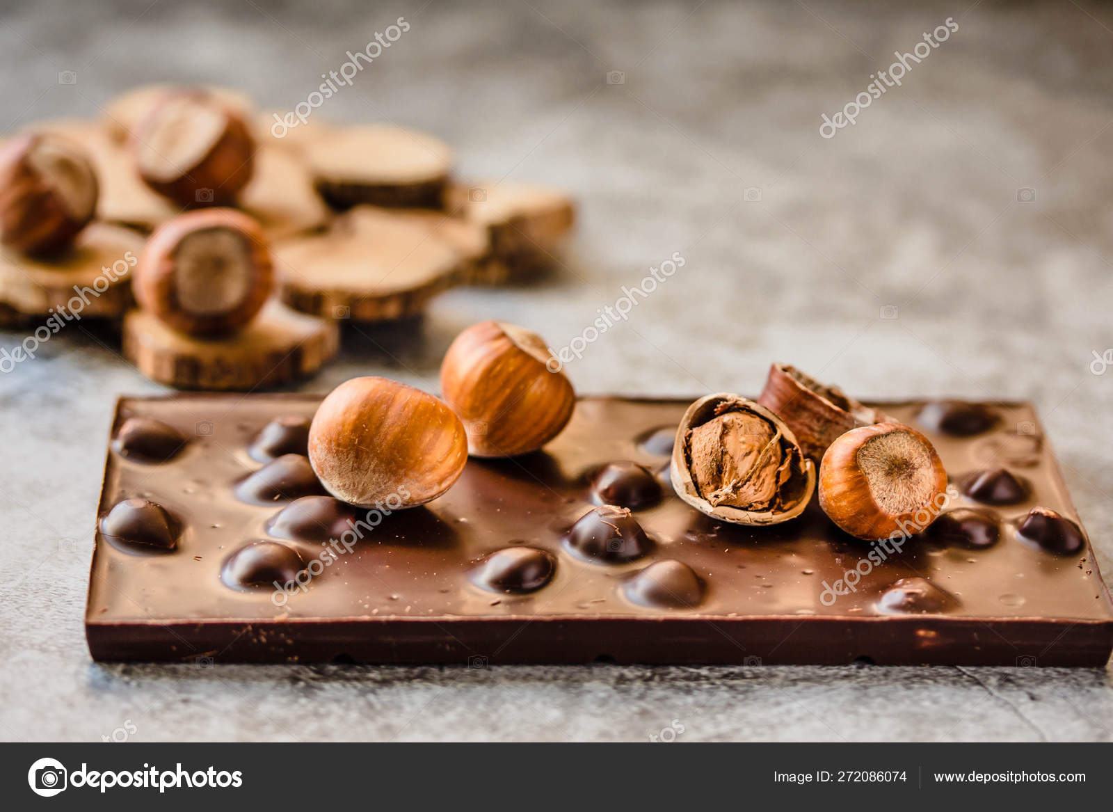 Dark chocolate with hazelnuts in the shel on gray backgroundl, c ...