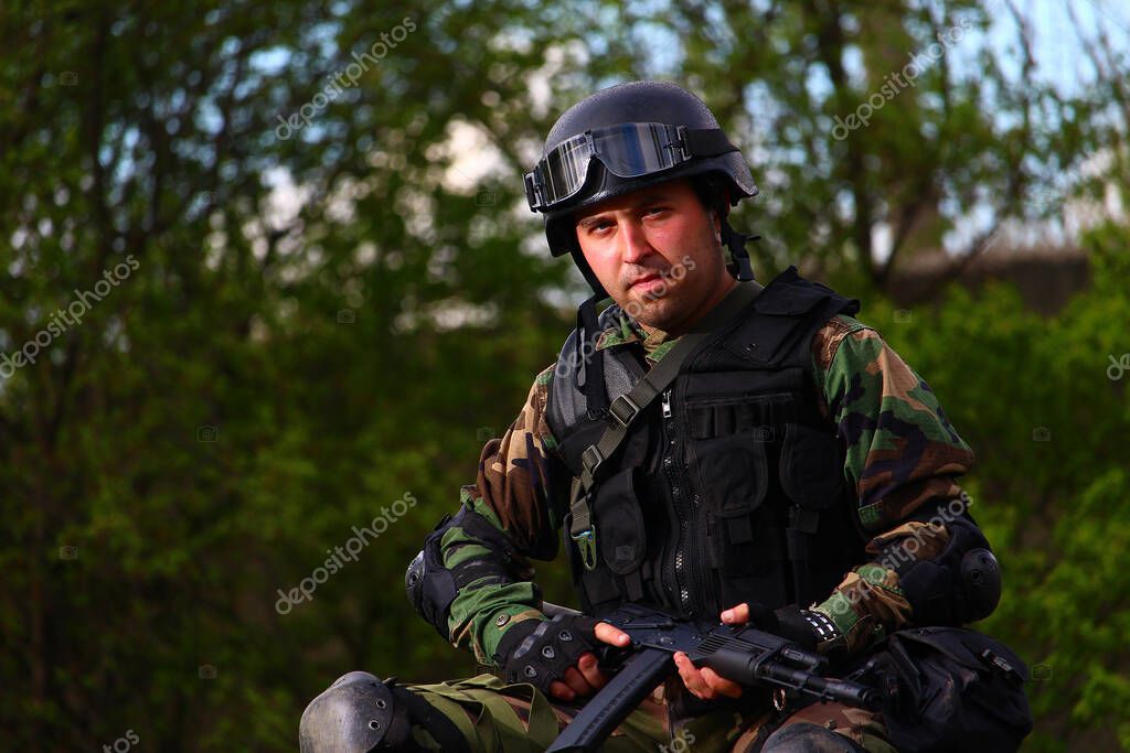 Un soldado con equipo de combate completo en un casco con un arma en ...
