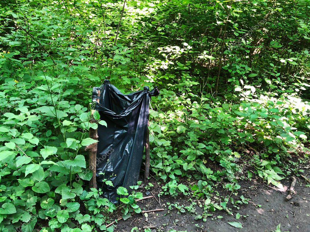 cubo de basura hecho a sí mismo de bolsa de plástico negro en palos de ...