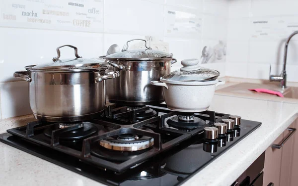 Utensils for cooking classes on stove in kitchen. Metal pans on kitchen ...