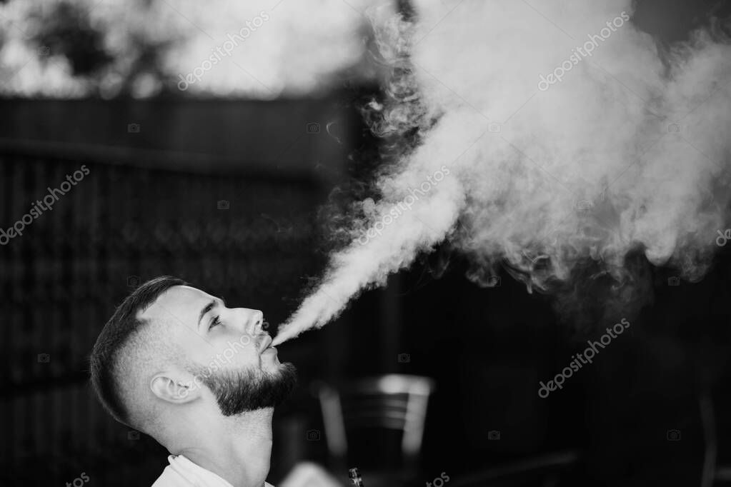 Joven chico guapo fumando narguile solo primer plano. Un joven fumando ...