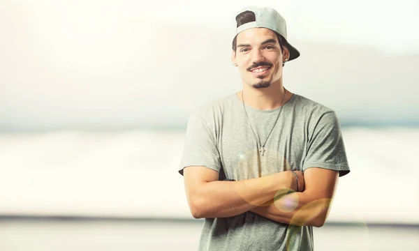 Young rapper man crossing his arms, smiling and happy, being confident ...