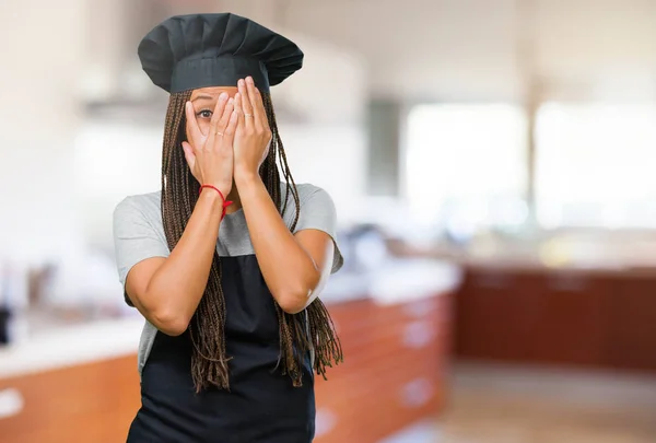 Portrait of a young black baker woman feels worried and scared, looking ...