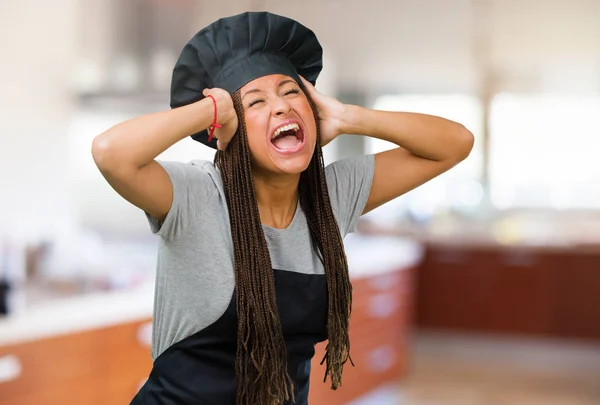 Portrait of a young black baker woman crazy and desperate, screaming ...