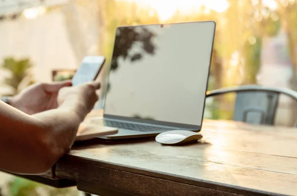 Selected focus computer mouse with man using cell phone and laptop on ...