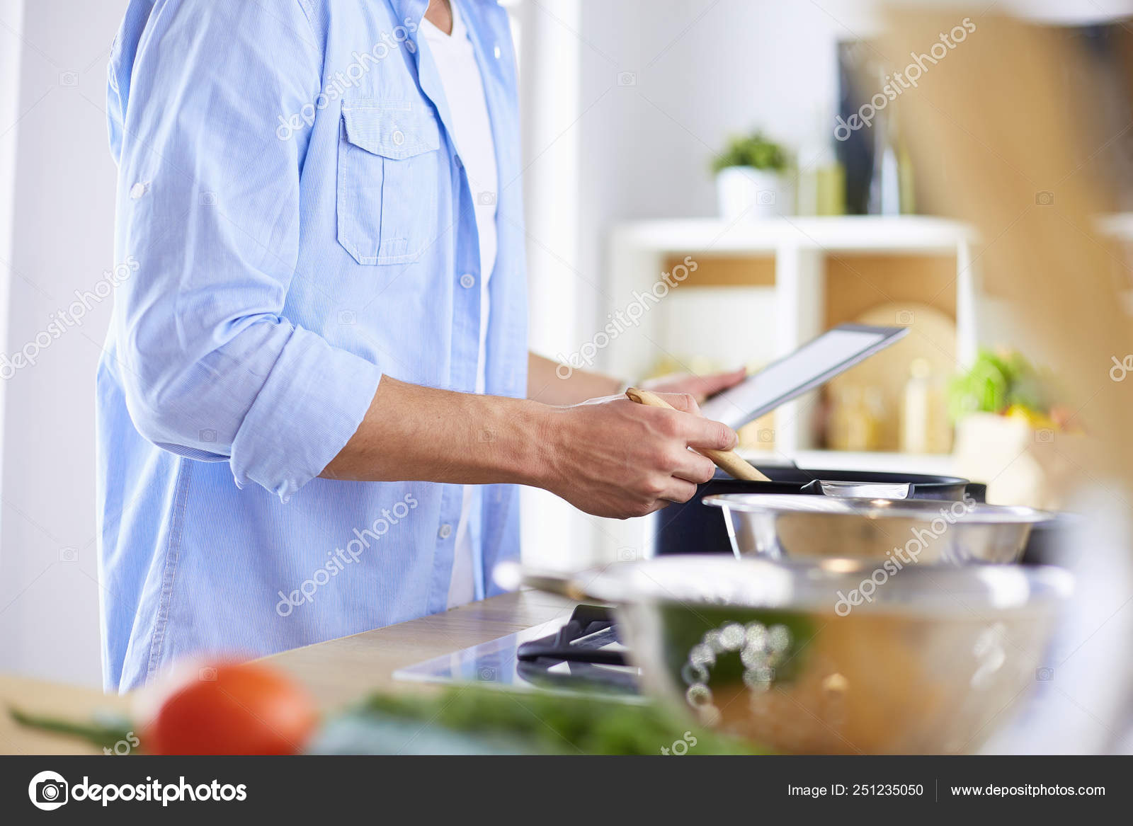 Man following recipe on digital tablet and cooking tasty and healthy ...