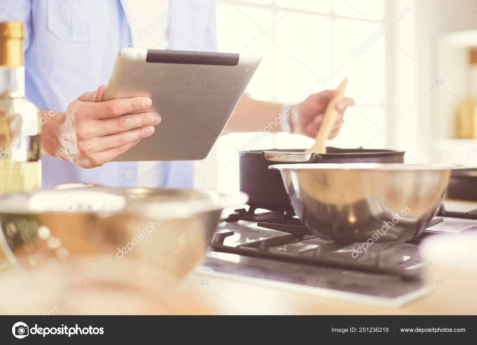 Man following recipe on digital tablet and cooking tasty and healthy ...