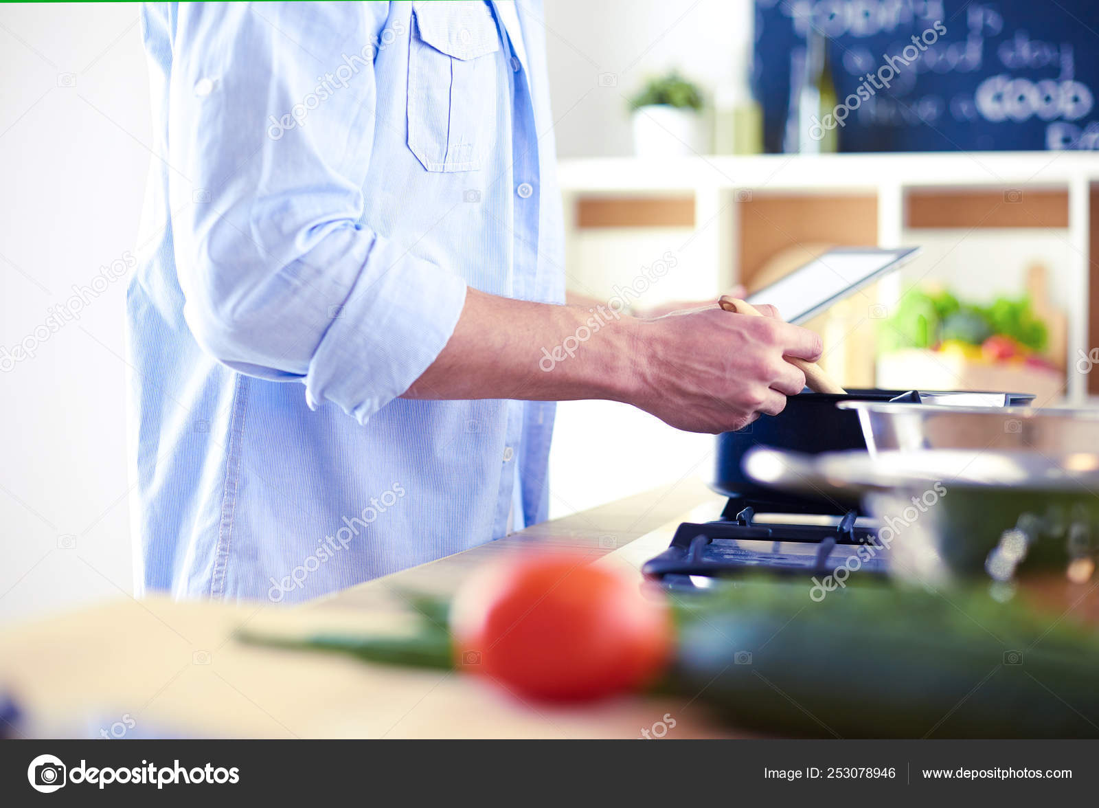 Man following recipe on digital tablet and cooking tasty and healthy ...