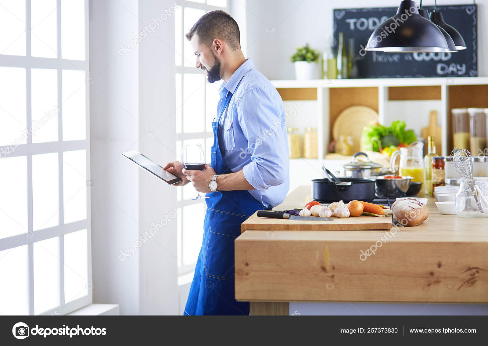 Man following recipe on digital tablet and cooking tasty and healthy ...
