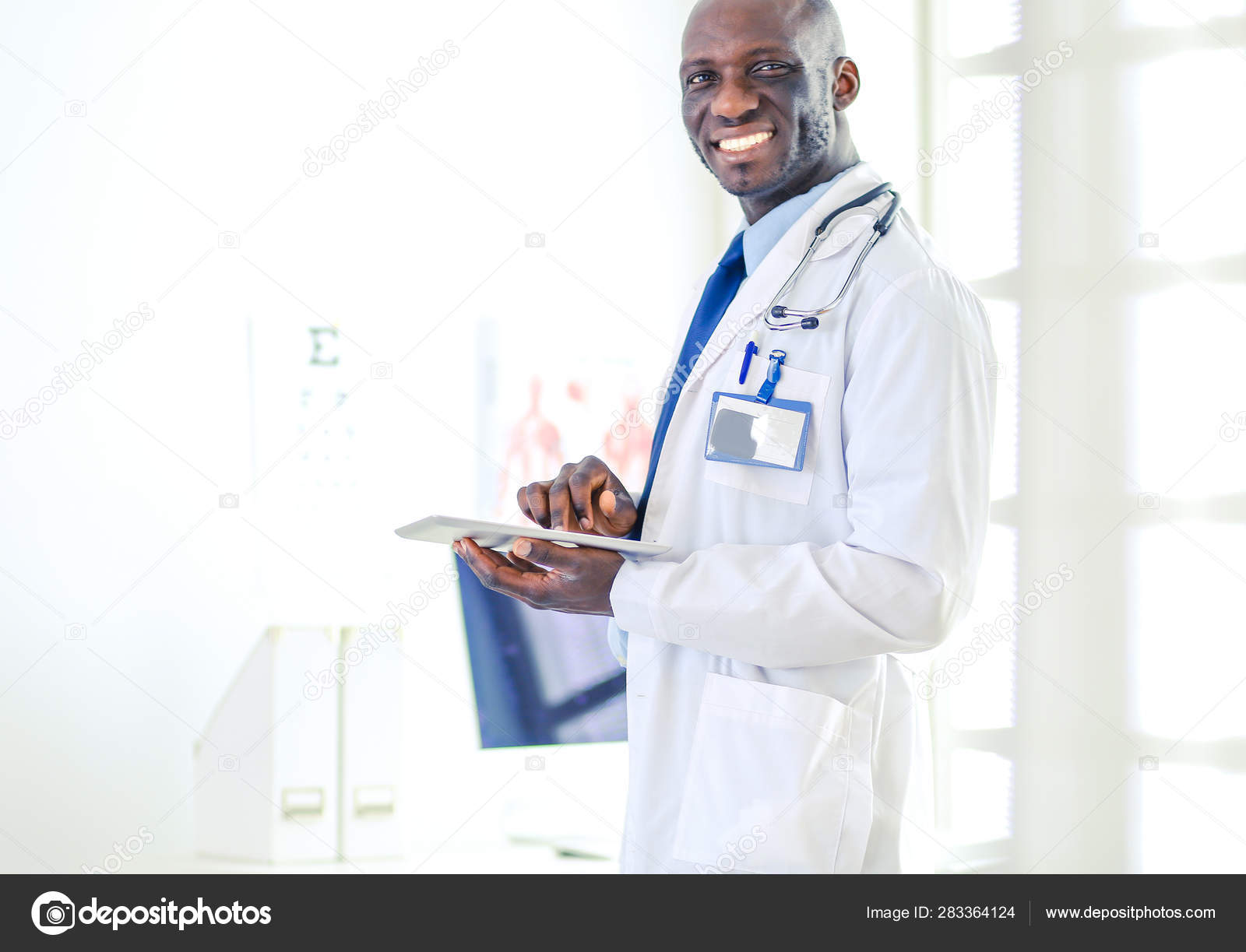 Male black doctor worker with tablet computer standing in hospital ...
