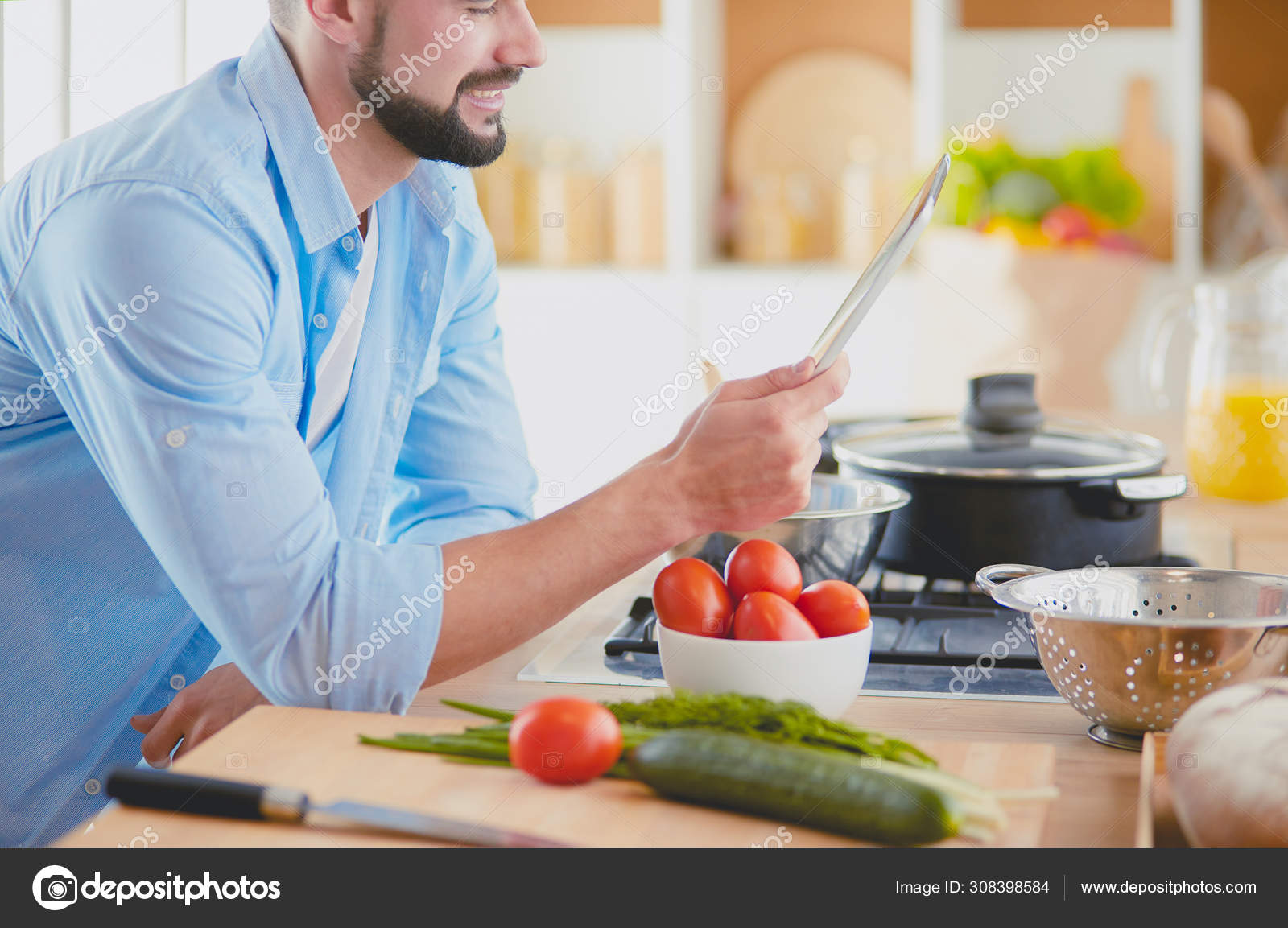 Man following recipe on digital tablet and cooking tasty and healthy ...