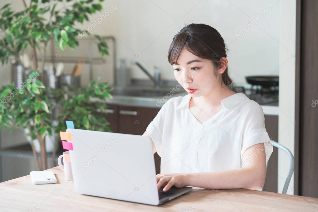Mujer asiática haciendo trabajo remoto con el ordenador portátil en la ...