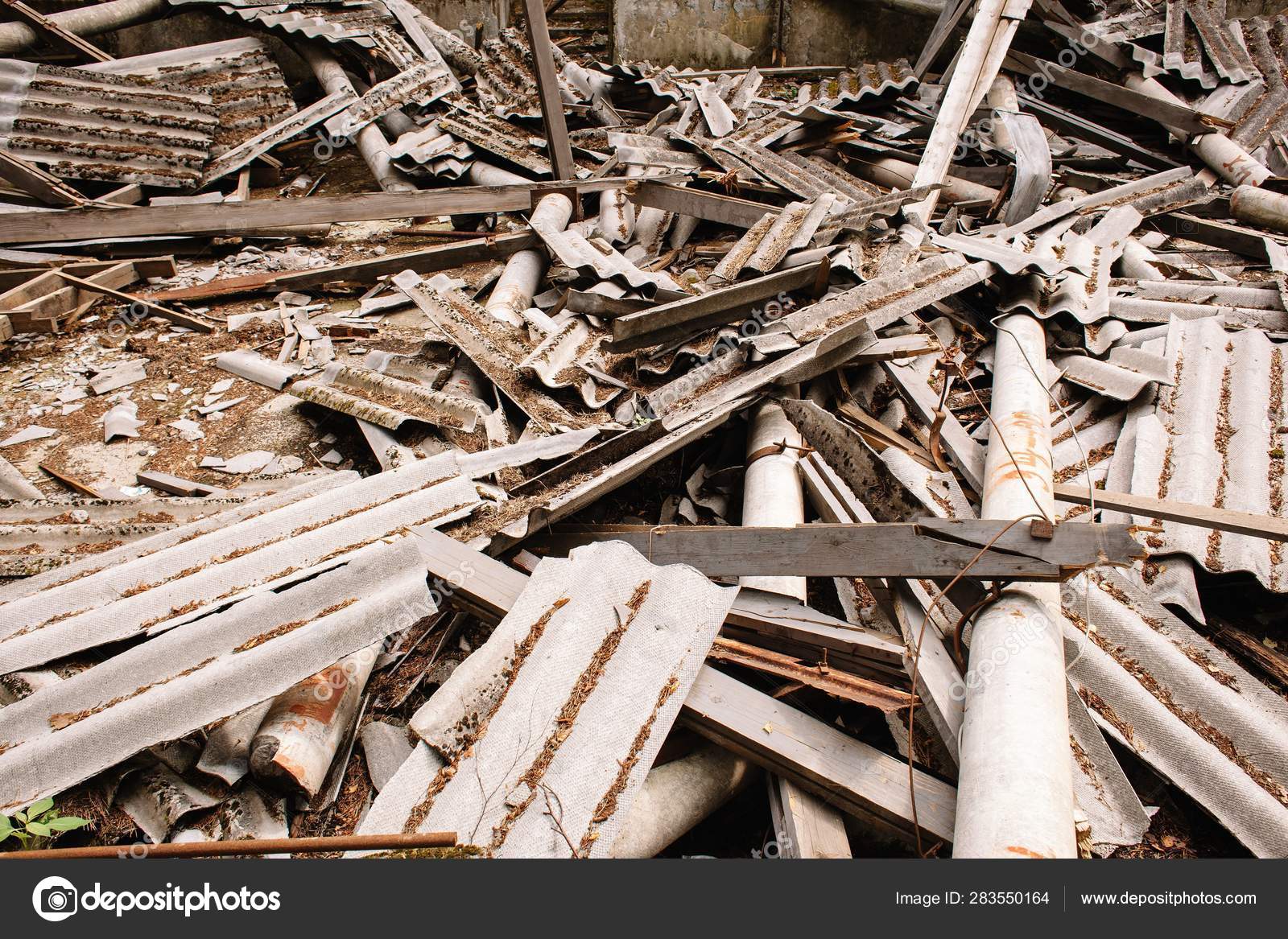 Dilapidated building with reinforced concrete columns and broken slate ...