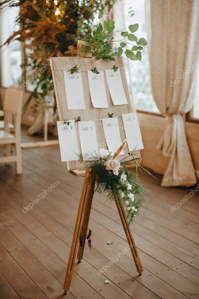 Plano de asientos, tablero de madera en un caballete, tarjetas de papel ...