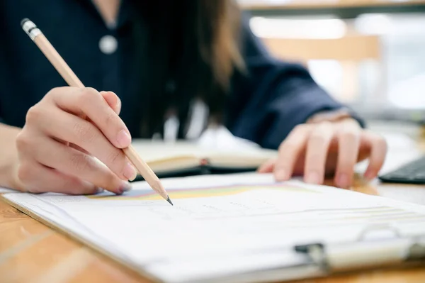 Closeup shot of female hand writing on paper work with pencil. - Stock ...