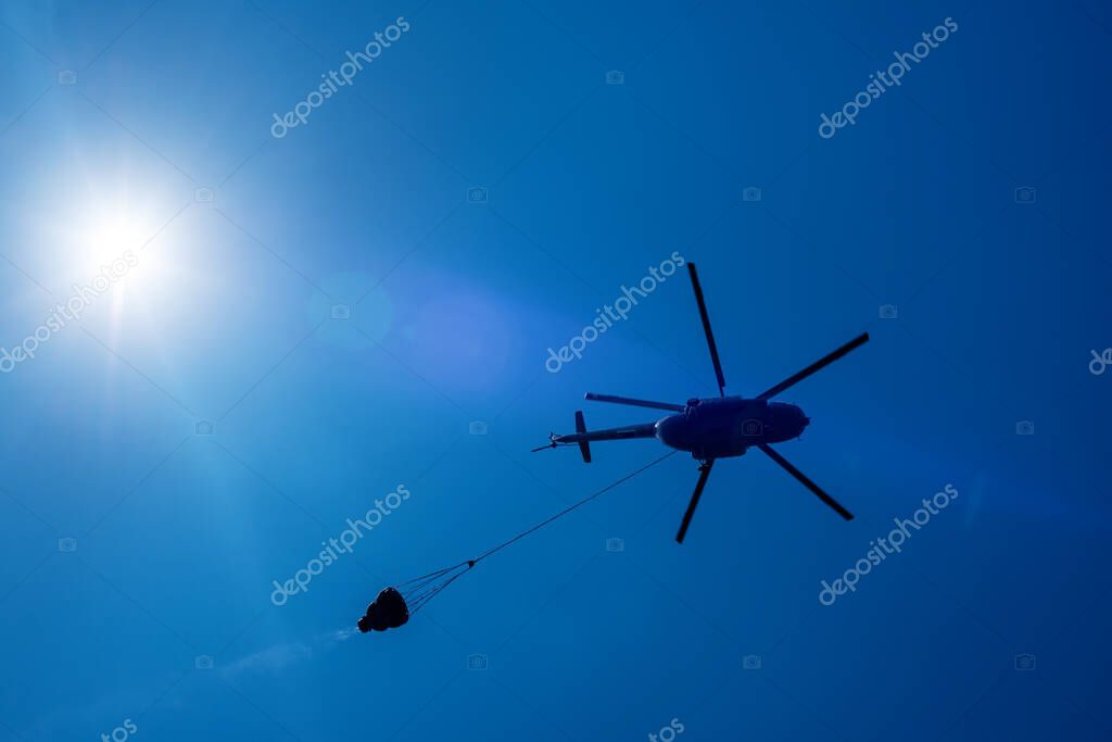 Silueta de un helic ptero de extinci n de incendios con equipo de fuego en un cielo azul con un ...
