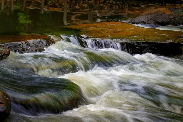 The water flows through the rocks in the stream. - Stock Image - Everypixel