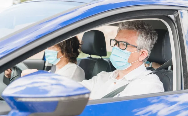 New normal. Driver with a medical face mask driving a car with a ...