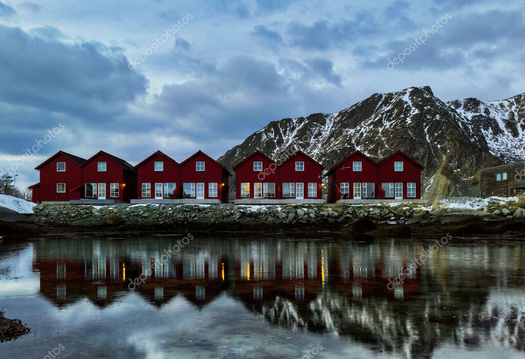 Una hilera simétrica de rorbu rojo clásico en Ballstad, isla de Lofoten ...