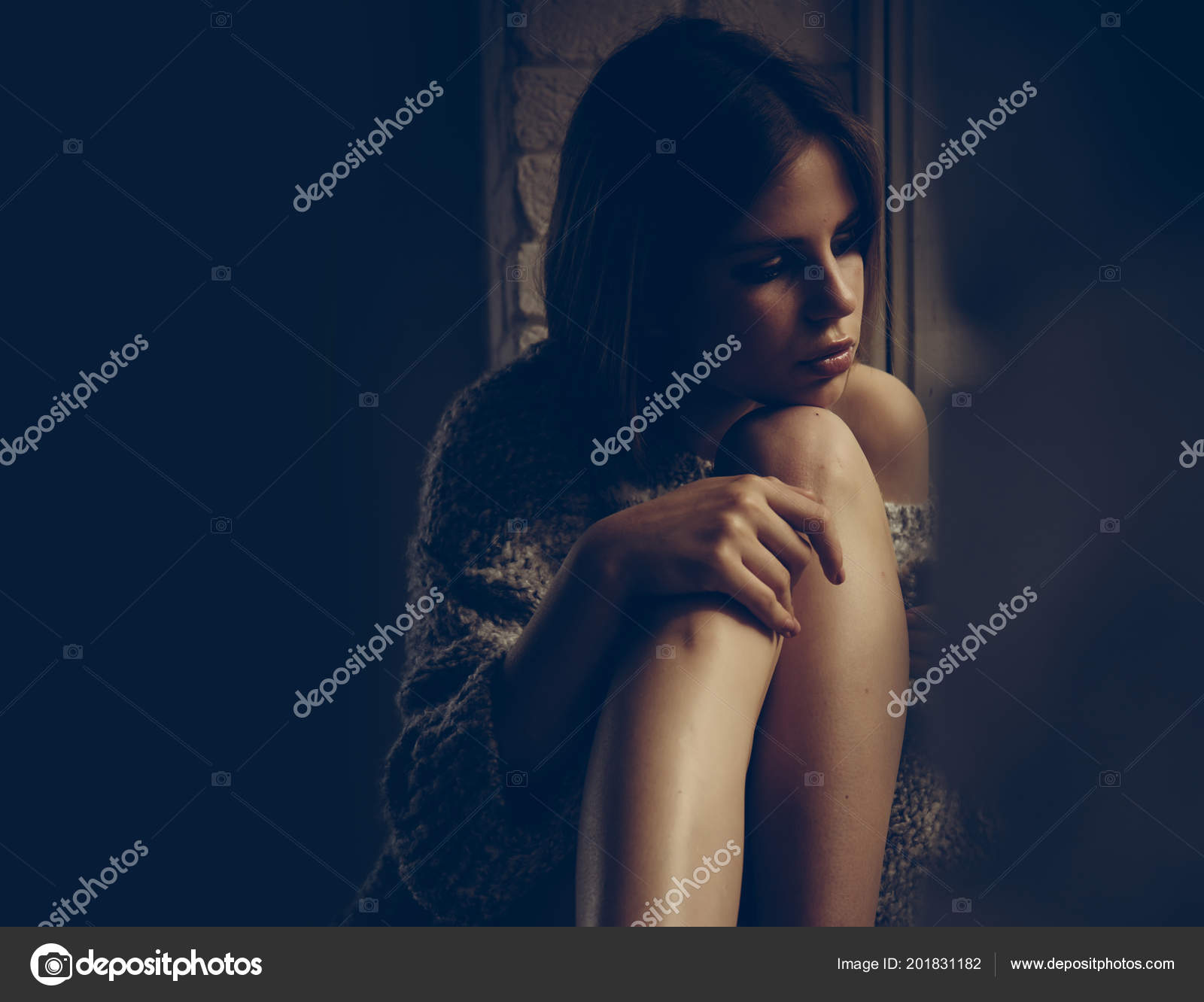 Alone with her thoughts. Woman sit with legs on window sill. Young woman with makeup and long ...