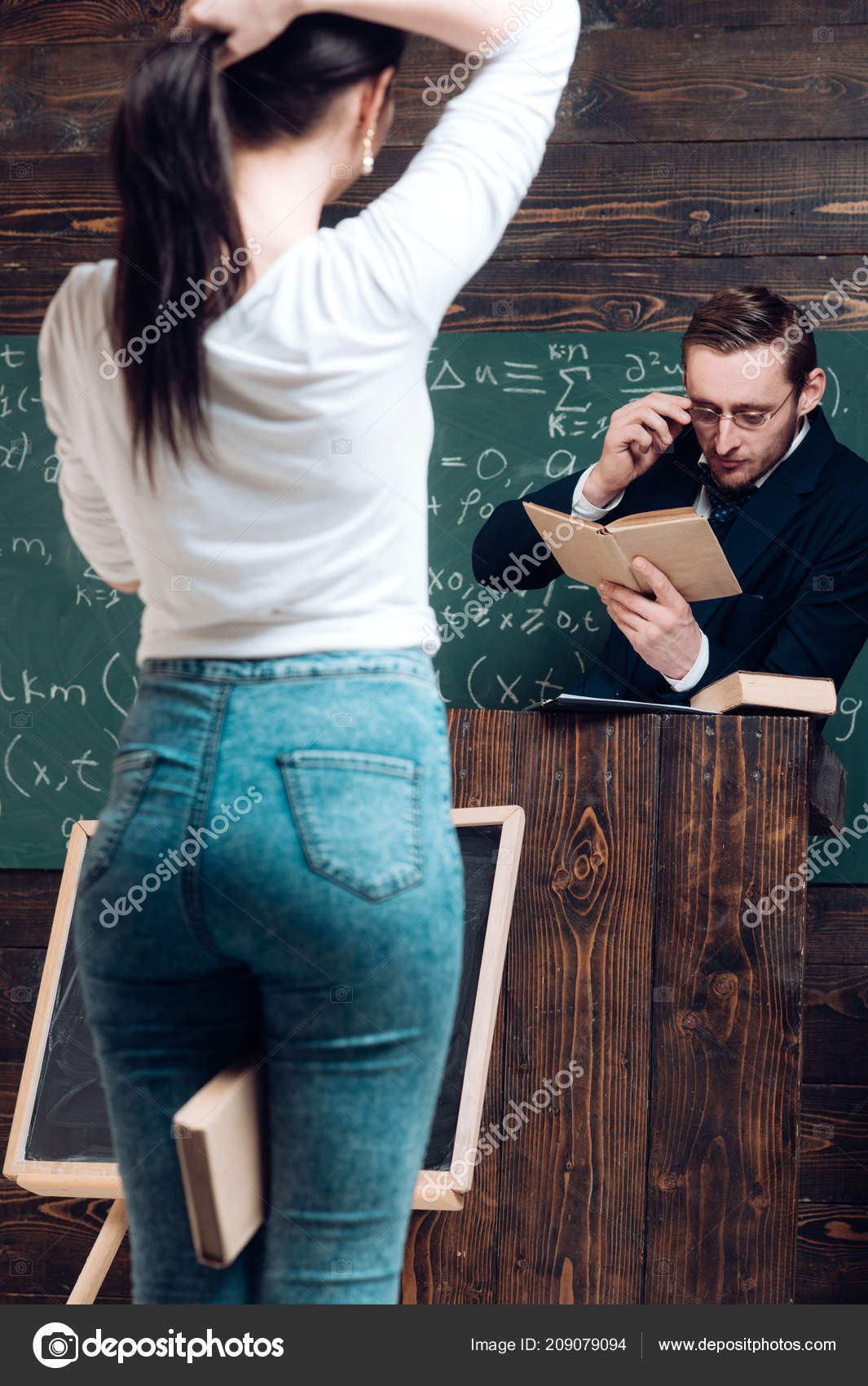 Blurred turn back girl holding a book between her legs and making a ...