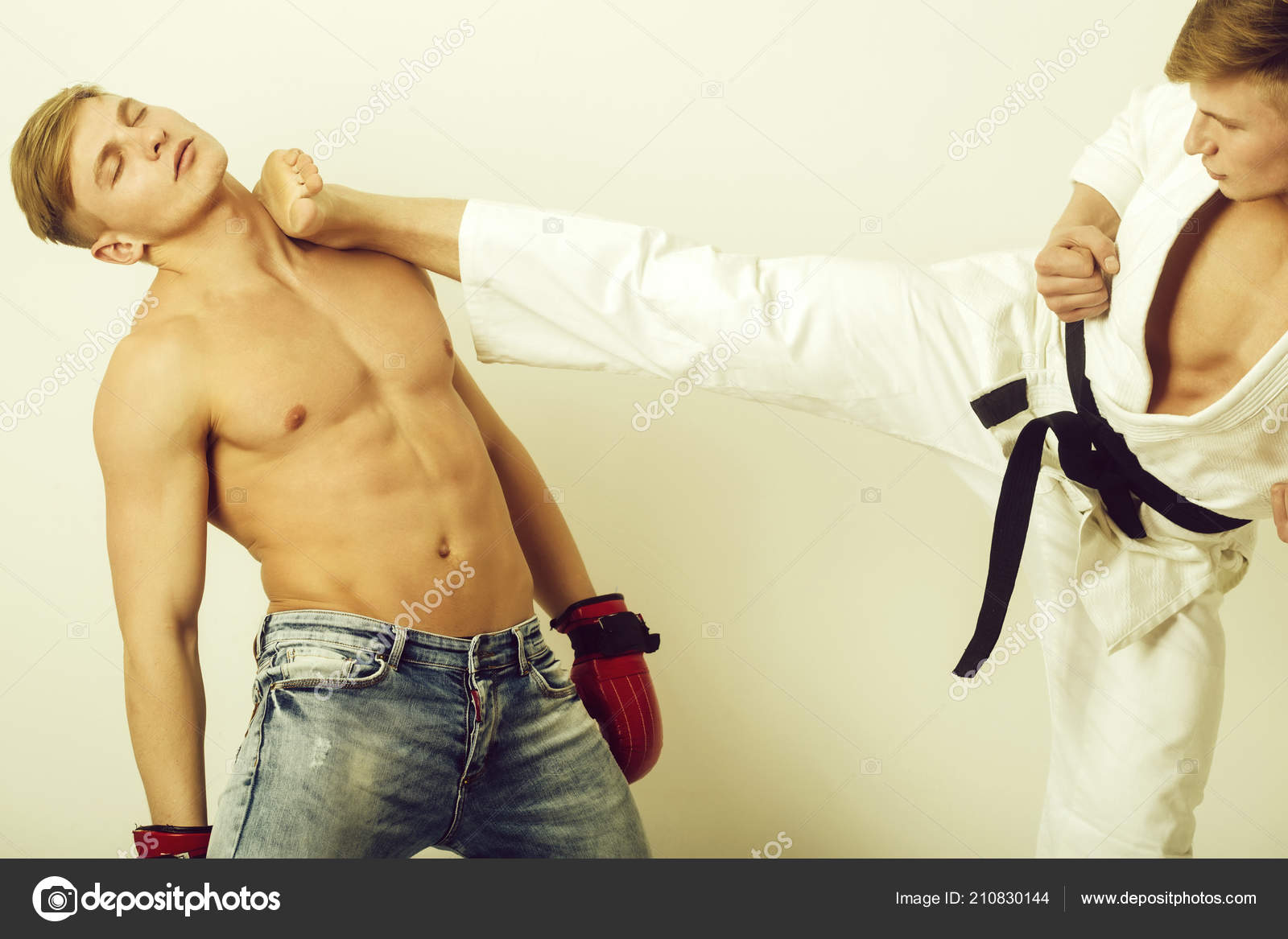 Fit karateka in kimono leg kicking head of boxer Stock Photo by ...