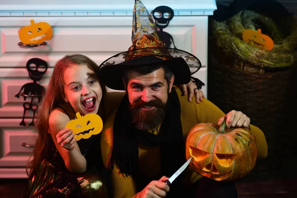 Father and daughter with Halloween decor. Wizard and little witch ...