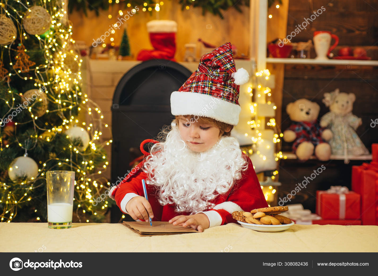 Santa kid writes the letter to children. Little Santa reads the letter ...