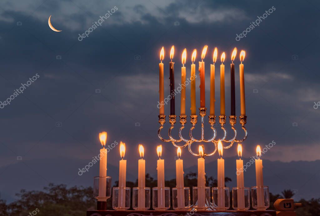 Menorah con velas encendidas contra la borrosa mañana nublada sobre las ...