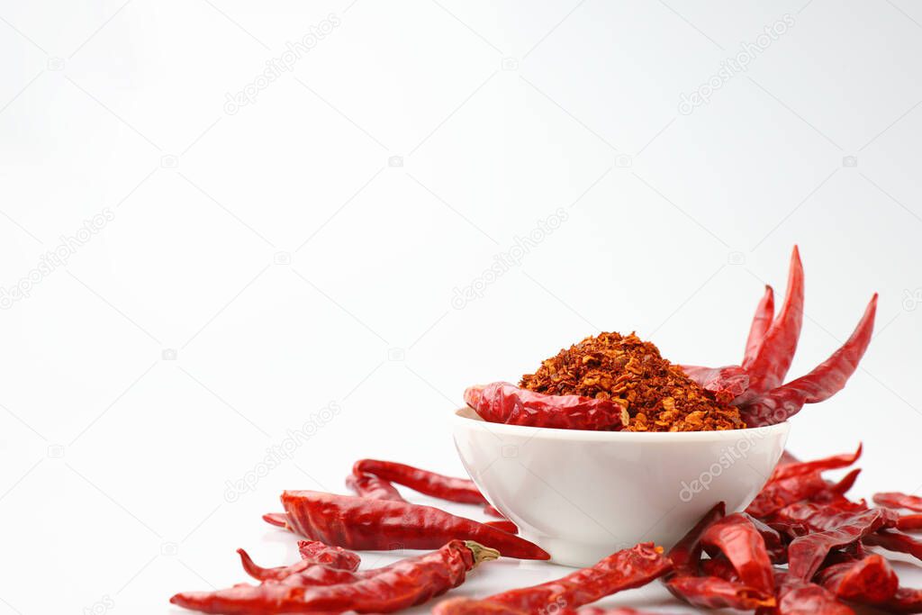 Pimienta de Cayena en una taza blanca con muchos chiles rojos secos ...